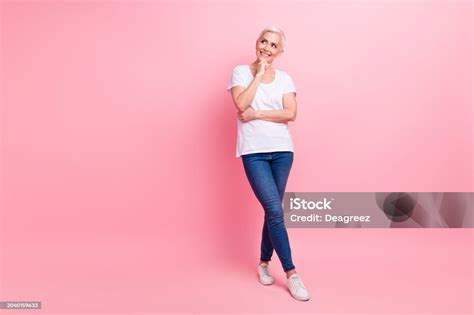 짧은 머리를 가진 마음 가진 여자의 전체 크기 사진 흰 티셔츠 청바지는 빈 공간을 생각하고 분홍색 배경에 고립 된 사업 아이디어를 생각합니다 55 59세에 대한 스톡 사진