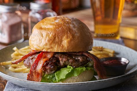 Thick Tasty Bacon Cheese Burger On Brioche Bun Served With Fries On
