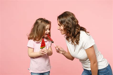 가벼운 옷에 여자는 귀여운 아이 아기 소녀와 재미가 있다 어머니 작은 아이 딸 파스텔 분홍색 벽 배경 스튜디오 초상화에 고립 어머니의 날 사랑 가족 부모가 어린 시절의 개념