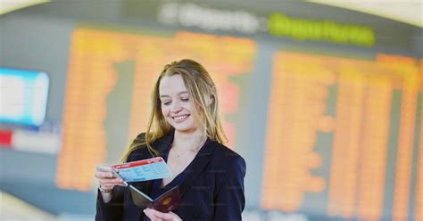 여권과 탑승권을 들고 국제 공항 터미널의 비행 정보 보드 근처에 서 있는 젊은 우아한 비즈니스 여성 사진 Unsplash의 양복 이미지