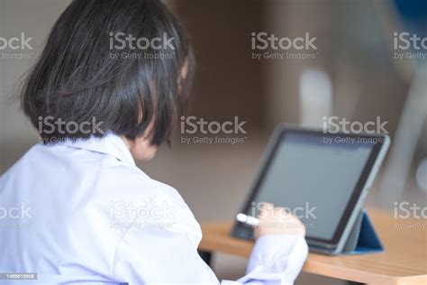 짧은 검은 머리를 가진 유니폼을 입은 동남아시아 여고생이 펜으로 태블릿에 그림을 그린다 교복에 대한 스톡 사진 및 기타 이미지 교복 교육 귀여운 Istock