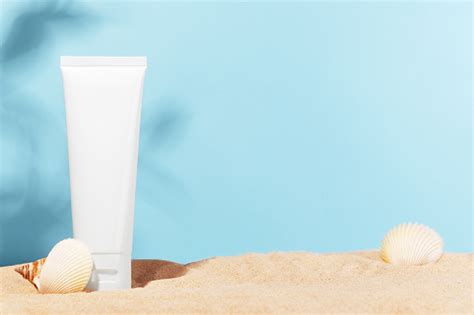 화장품 플라스틱 튜브 영양 또는 보습 크림 마스크 조개와 모래와 해안 배경에 로션을위한 용기 복사 공간이 있는 빈 브랜드 가문 없는 모형입니다 유기농 천연 화장품 배경