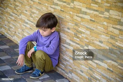 학교에 혼자 앉아 슬픈 어린 소년은 그의 얼굴을 숨깁니다 격리 및 괴롭힘 개념 아이는 슬프고 불행했고 아이는 울고 화가 났고 아프다 고독 개념에 대한 스톡 사진 및 기타