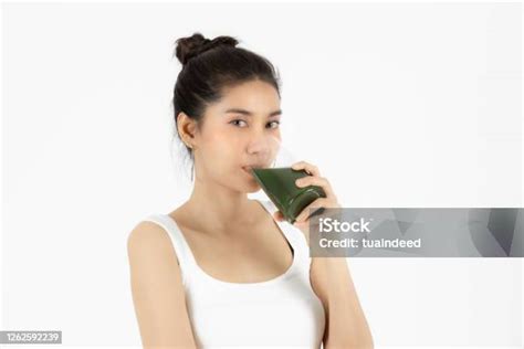 건강한 젊은 아시아 여성은 흰색 고립 된 배경 위에 녹색 해독 야채 스무디를 마시는 채식 음료 주스 건강한 라이프 스타일 피트니스 및 건강 관리 개념 가냘픈에 대한 스톡