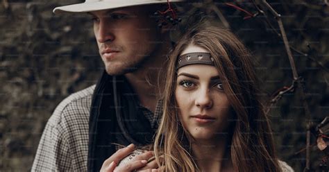 아름 다운 갈색 머리 집시 소녀 보헤미안 화이트 스웨터를 입은 힙 스터 여자는 카우보이 모자에 잘 생긴 남자와 손을 잡고 무료