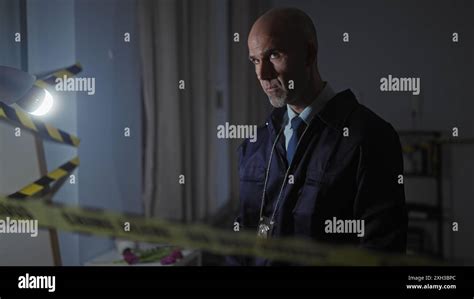 Bald Detective With Beard Analyzing Indoor Crime Scene At Night With