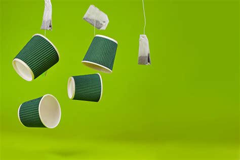 일회용 골판지 컵과 티백이 공중에서 날아오다 녹색 배경에 종이 컵 안경 근처에 텍스트를 위한 공간과 여유 공간을 복사합니다 가방에 대한 스톡 사진 및 기타 이미지 Istock