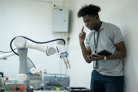 trainee robotics engineer learning with programming and manipulating robot hand industrial