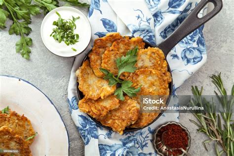 감자 Latkes 전통적인 유태인 팬케이크 사 우 어 크림 파 슬 리 마른 붉은 고추 부스러기와 민트 소스 파란 꽃 배경 흰색 냅킨입니다 Hannukah 축 하 요리