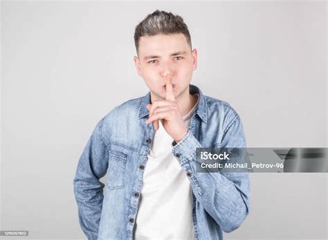 회색 배경을 통해 젊은 잘 생긴 남자는 입술에 손가락으로 조용히 요청 침묵과 비밀 개념 20 24세에 대한 스톡 사진 및 기타 이미지 20 24세 개념 남성 Istock