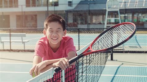 젊은 건강 하 고 행복 한 Tween Preteen 혼합 아시아 소년 테니스 초보자 선수 에 야외 블루 코트 활성 어린이 스포츠 학생 학교 캠프 건강한 생활방식에 대한 스톡