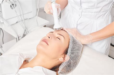 미용사는 Phonophoresis를 사용하여 회춘 여성 얼굴을 위해 초음파 피부 강화를 만듭니다 30 34세에 대한 스톡 사진