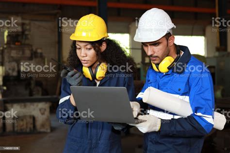 보호복을 입은 기술자 엔지니어 그룹과 중공업 제조 공장에서 제어 또는 유지 보수 작업 선반 금속 기계를 제어하는 동안 청사진이 있는 작업 컴퓨터 16 17 살에 대한 스톡