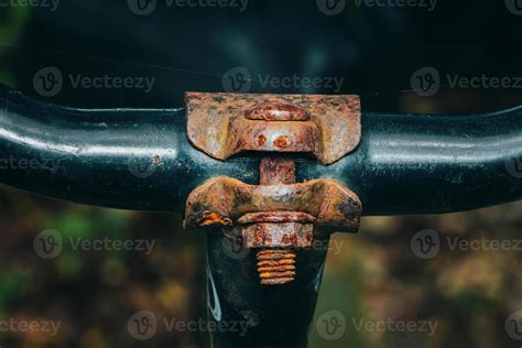Close Up Of A Rusty Bolt And Bracket Securing A Black Metal Bar