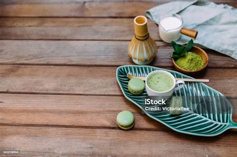 일본 녹색 말차 라떼 말차 가루 오래된 나무 보드에 채찍질대나무 거품기 항산화물질이 풍부한 건강한 유기농 제품인 말차 차 맨 위 보기입니다 요리하기 음식 준비에 대한 스톡