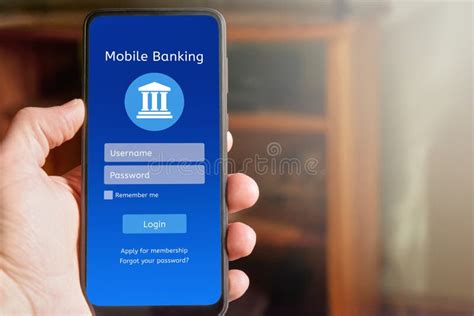 Male Hand Holding Mobile Phone With Online Banking App Interface On The Screen Login Page With