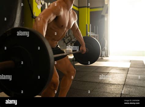 Side View Of Crop Anonymous Male Athlete With Naked Torso Performing Snatch Exercise With Heavy