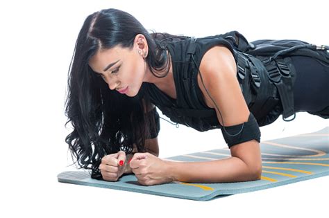 Ems 양복을 입은 한 젊은 운동 여성이 고립된 흰색 배경에 매트에서 판자 운동을 합니다 Ems 교육 전기 근육 자극기 근육에 대한 스톡 사진 및 기타 이미지 Istock