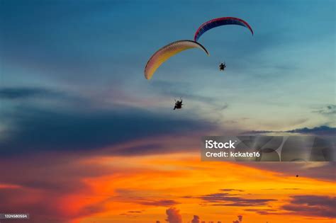 부드러운 초점에 비행 낙하산의 스카이 다이빙 일몰 풍경 파라 모터 플라잉 실루엣과 선 세트 일몰과 함께 저녁 하늘에서 비행 패러 글라이더의 실루엣 2명에 대한 스톡 사진 및