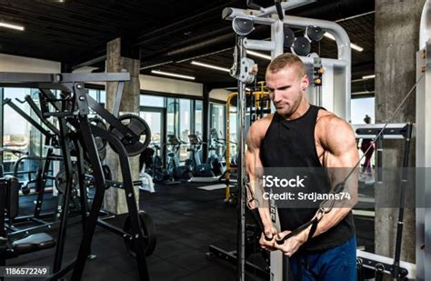 젊은 강한 땀이 집중 맞는 근육 보디 맨 가슴 스트레칭 운동 에 케이블 기계 에 체육관에서 강도와 근육 훈련의 좋은 찾고 20