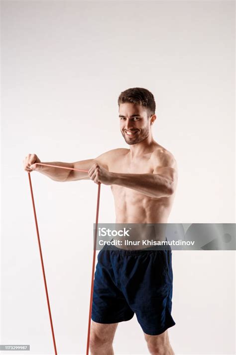 그의 손에 체조 탄성 밴드와 흰색 배경에 수염을 가진 젊은 스포티 한 남자 고무 밴드로 훈련 강사에 대한 스톡 사진 및 기타 이미지 Istock