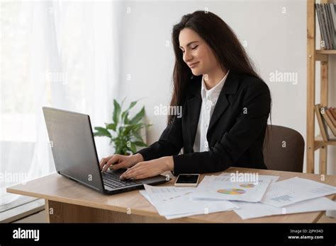 Portrait Of A Beautiful Woman Data Analyst Sitting At A Desk Working On