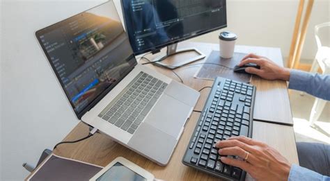 Premium Photo Programmer Drinking Coffee While Using Laptop On Table