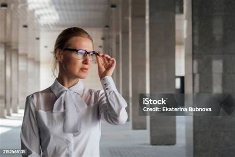 학교나 대학 건물을 배경으로 흰 셔츠와 안경을 쓴 젊고 아름다운 금발의 교사 또는 학생 40 44세에 대한 스톡 사진 및 기타