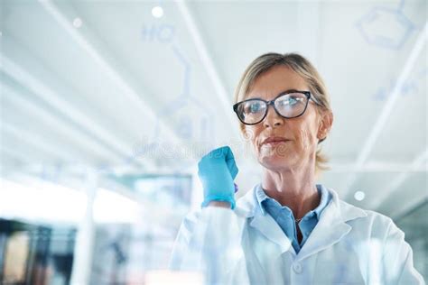 Woman Scientist And Think With Formula On Glass Wall At Laboratory For Planning Strategy And