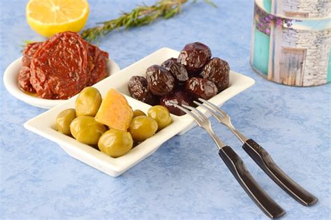 그리스 요리의 요리 세트 올리브 태양 건조 토마토 레몬 근대의 뿌리 올리브유와 전통적인 건조 빵 항아리 전통 그리스 음식입니다