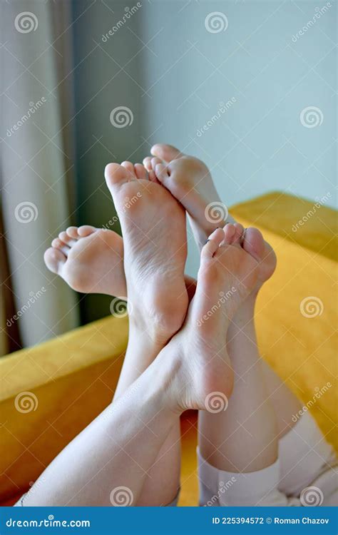 Loving Young Lesbian Couple Embracing On Sofa Feet Close Up Copy