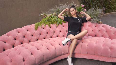 Selena Gomez Is Sitting On Dark Peach Color Couch Wearing Black Dress