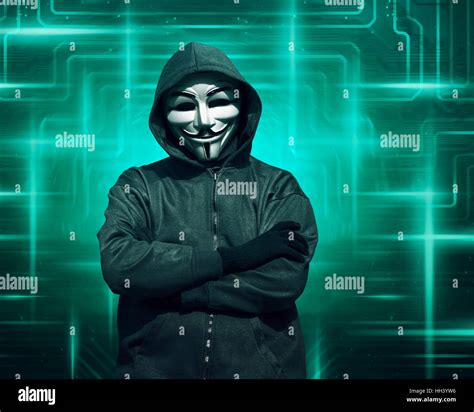 Hooded Hacker With Mask Standing Against Digital Visual Screen