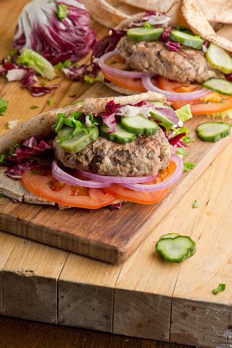 피타 빵에 양고기 버거 또는 치즈 버거 고전적인 그리스 또는 미국 양고기 버거는 양념 양고기 베이컨 페타 치즈 Tzatziki 캐러멜 양파 양상추 토마토 그리고 바삭바삭한