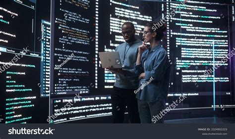 Portrait Of Two Diverse Developers Using Laptop Computer With Code Over 105 Royalty Free