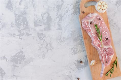 후추 마늘 로즈마리가 포함 된 돼지고기 스테이크 원시 고기 나무 커팅 보드에 거짓말 회색 돌 배경에 공간을 복사 합니다 텍스트에 대 한 장소 사진 고기에 대한 스톡 사진 및