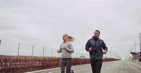 흐린 날 시골의 도로를 따라 함께 달리는 운동복을 입은 다양한 젊은 부부 사진 Unsplash의 여자 친구와 남자 친구 이미지