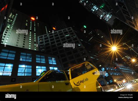 Low Angle Shot Of A Yellow Taxi Cab Stopping Along The Roadside Opening