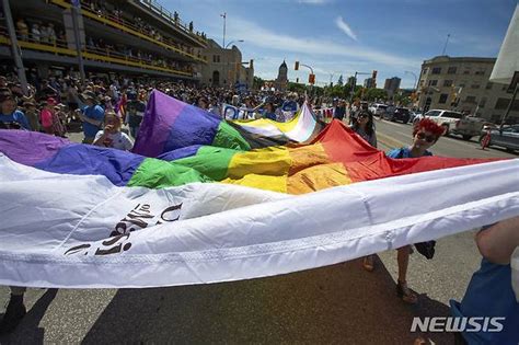 무지개 깃발 들고 행진하는 사람들