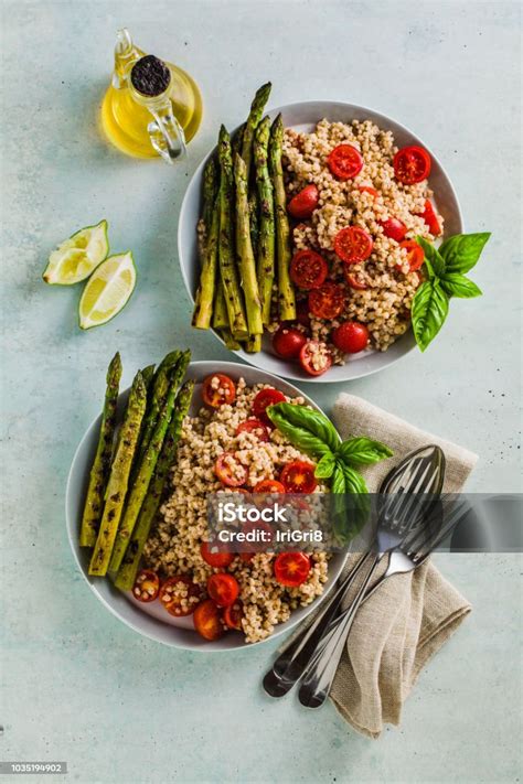 샐러드 글루텐 밀 구운 아스파라거스와 체리 토마토 Tahini 참 깨 파스타 소스와 라임 주스와 테이블에 접시에 체 강 질병을 가진 환자에 대 한 건강 한 채식 요리 건강한