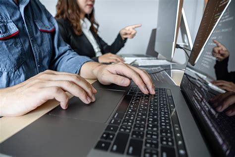 两名专业程序员在公司台式电脑上合作开发网站项目，编码和输入数据代码，使用html Php和java模板素材 稿定设计