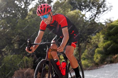 Мужчина едет на велосипеде на велосипеде и в шлеме Бесплатно Фото