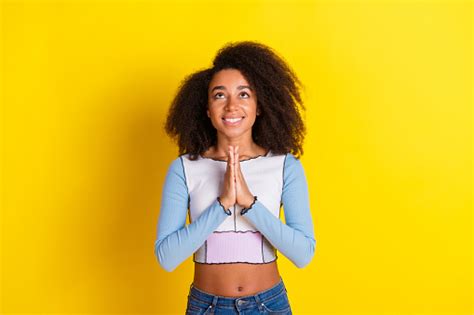 파마 Coiffure 옷을 입은 셔츠 손바닥을 함께 기도하는 고마운 소녀의 사진 노란색 배경에 고립 된 빈 공간을 바라 봅니다 검정 머리에 대한 스톡 사진 및 기타 이미지