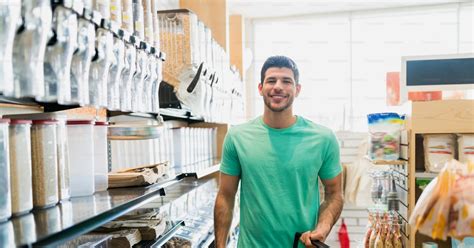 식료품점에서 쇼핑하는 동안 바구니를 들고 있는 행복한 라틴 청년 사진 Unsplash의 슈퍼마켓 이미지