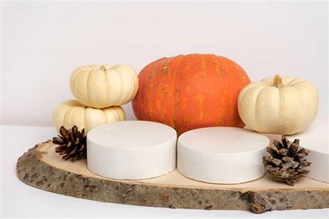 흰 벽 배경에 크리스마스 트리 장식이 있는 나무 스탠드에서 프레젠테이션을 위한 연단 현대 기하학적 형태 실린더 구 제품을