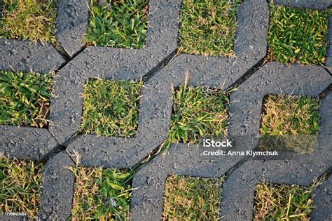 회색 자연석으로 만든 사각형 타일의 배경 질감입니다 도로의 콘크리트 가로 기하학적 포장 패턴 녹색 잔디 및 생태 주차장 녹색 주차 지속 가능한 개발 도시 도시에 대한 스톡