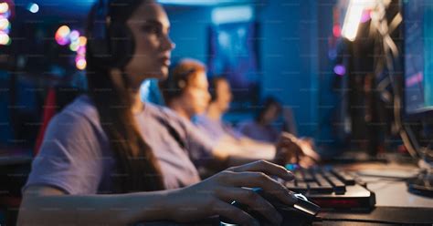 개인용 컴퓨터 안락의자가 있는 전문 사이버 게이머 스튜디오 룸에 앉아 있는 사람들 네온 색상의 흐릿한 배경으로 스트리밍을 위한 키보드 여성의 손에 초점 맞추기 사진