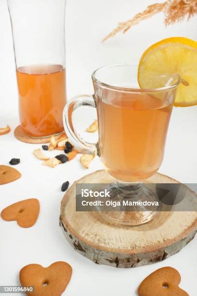 말린 과일에서 수제 음료 한 병과 흰색 배경에 심장의 형태로 콤포트와 쿠키와 유리 찻잔 엽서 달력의 개념입니다 수직 음식 사진 맨 위 보기입니다 건강한 생활방식에 대한 스톡