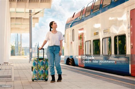 짐을 들고 기차역에서 출발을 기다리는 젊은 여성 배경에 화려한 기차 여행과 휴가의 개념 25 29세에 대한 스톡 사진 및 기타 이미지 25 29세 Brand Name
