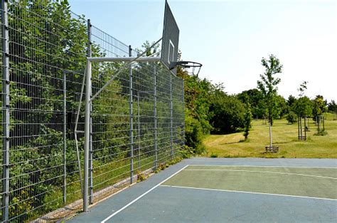 학교에서 볼 게임을위한 다기능 야외 놀이터 라인이있는 플라스틱 카펫에서 녹색 인조 잔디 농구 농구와 축구 목표 높은 그물과 가드레일을 잡는 주변 0명에 대한 스톡 사진 및